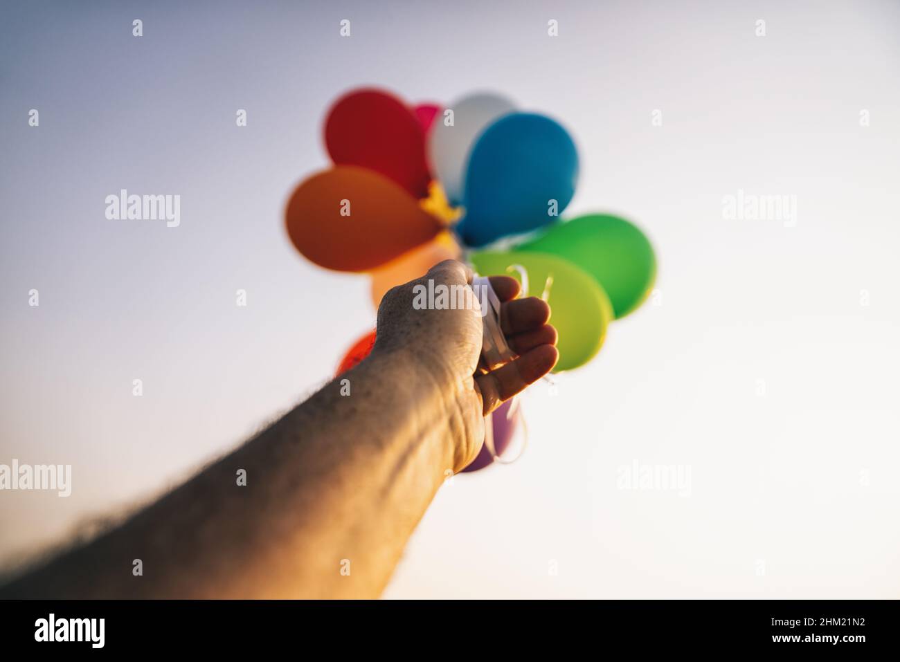 hand holding bunch of Colorful balloons Stock Photo - Alamy