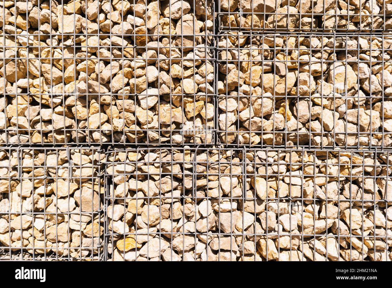 Stone wall in metallic net Stock Photo - Alamy