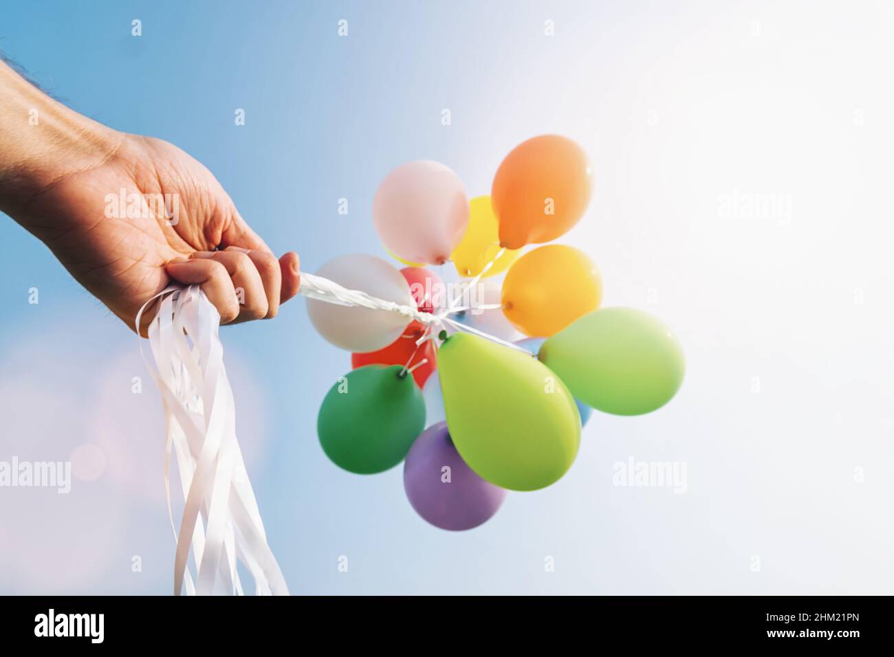 hand holding Colorful balloons Stock Photo - Alamy
