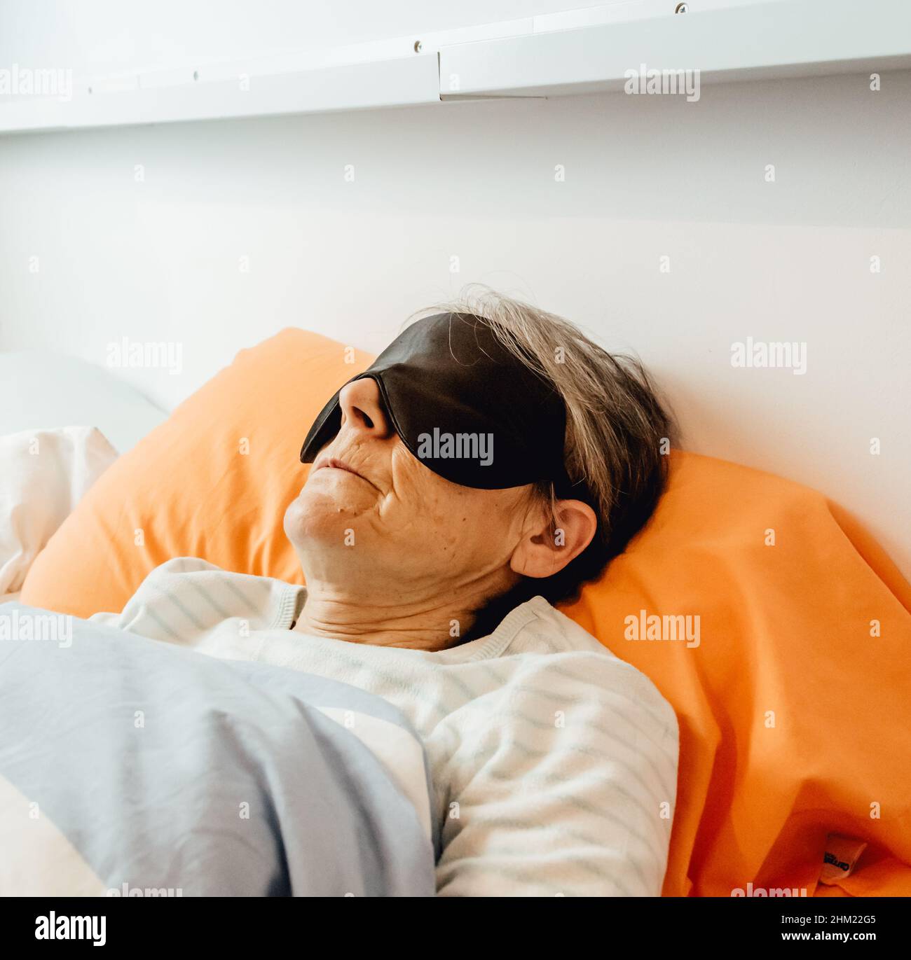 An old lady sleeping using a face mask in a modern bedroom Stock Photo ...