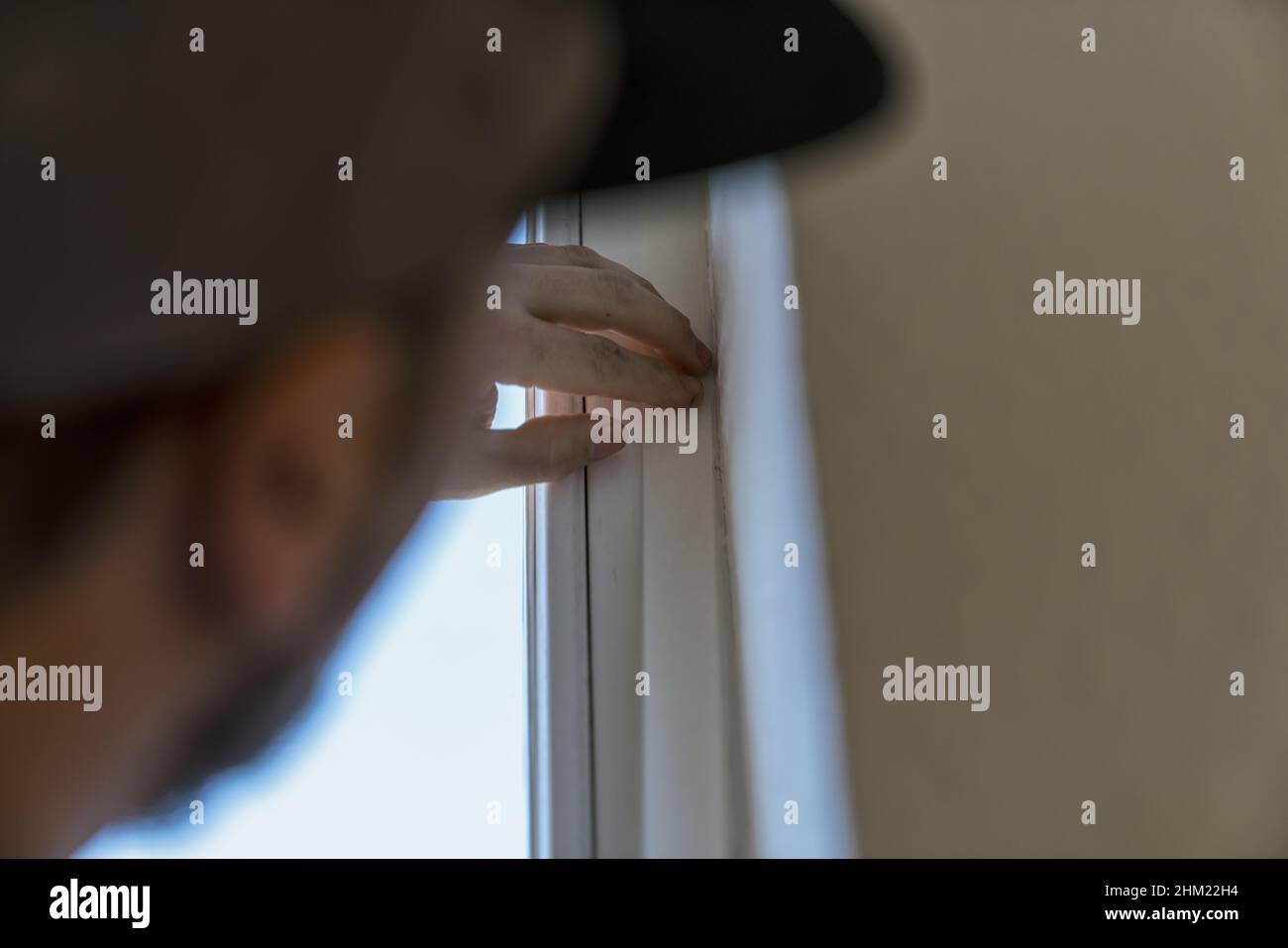 painter prepared a room window with masking tape to paint the room with ...