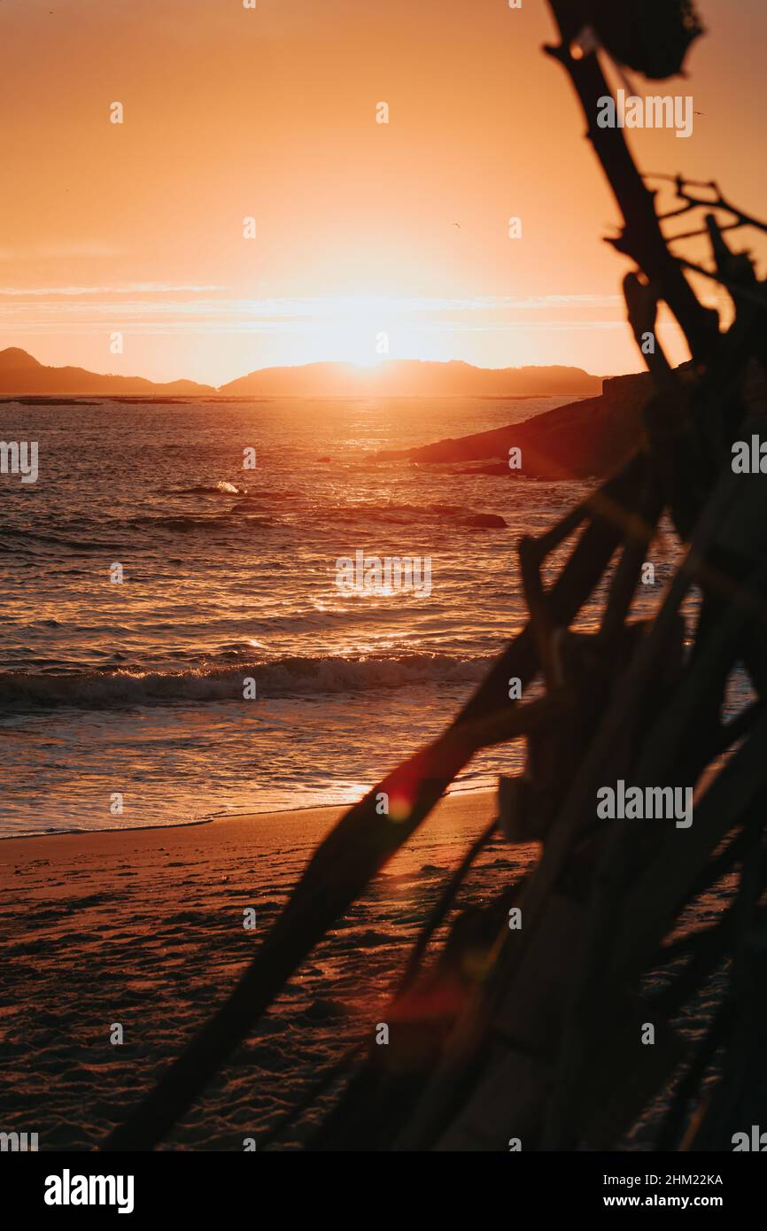 A bonfire on the beach during a colorful massive sunset over it Stock ...