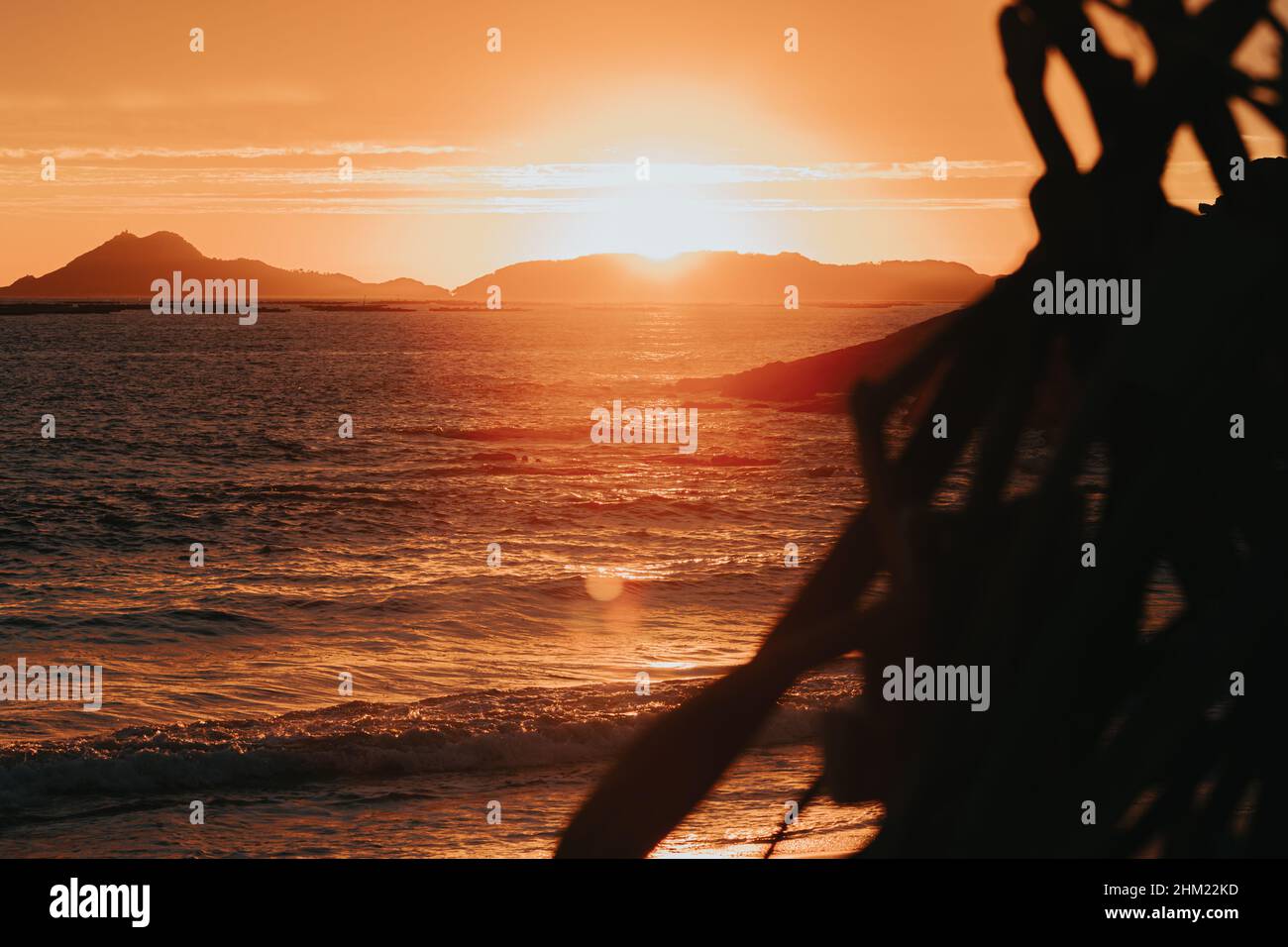 A bonfire on the beach during a colorful massive sunset over it Stock ...