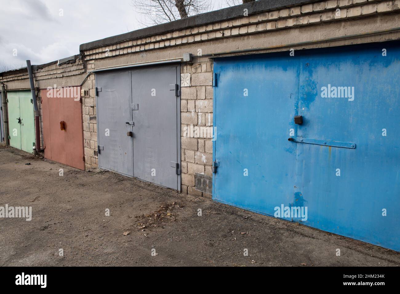 Old rusty multi-colored garages with bad road. Garage cooperative Stock ...