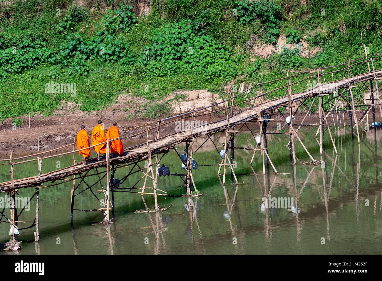 Buddhist monks crossing rustic bridge Stock Photo - Alamy