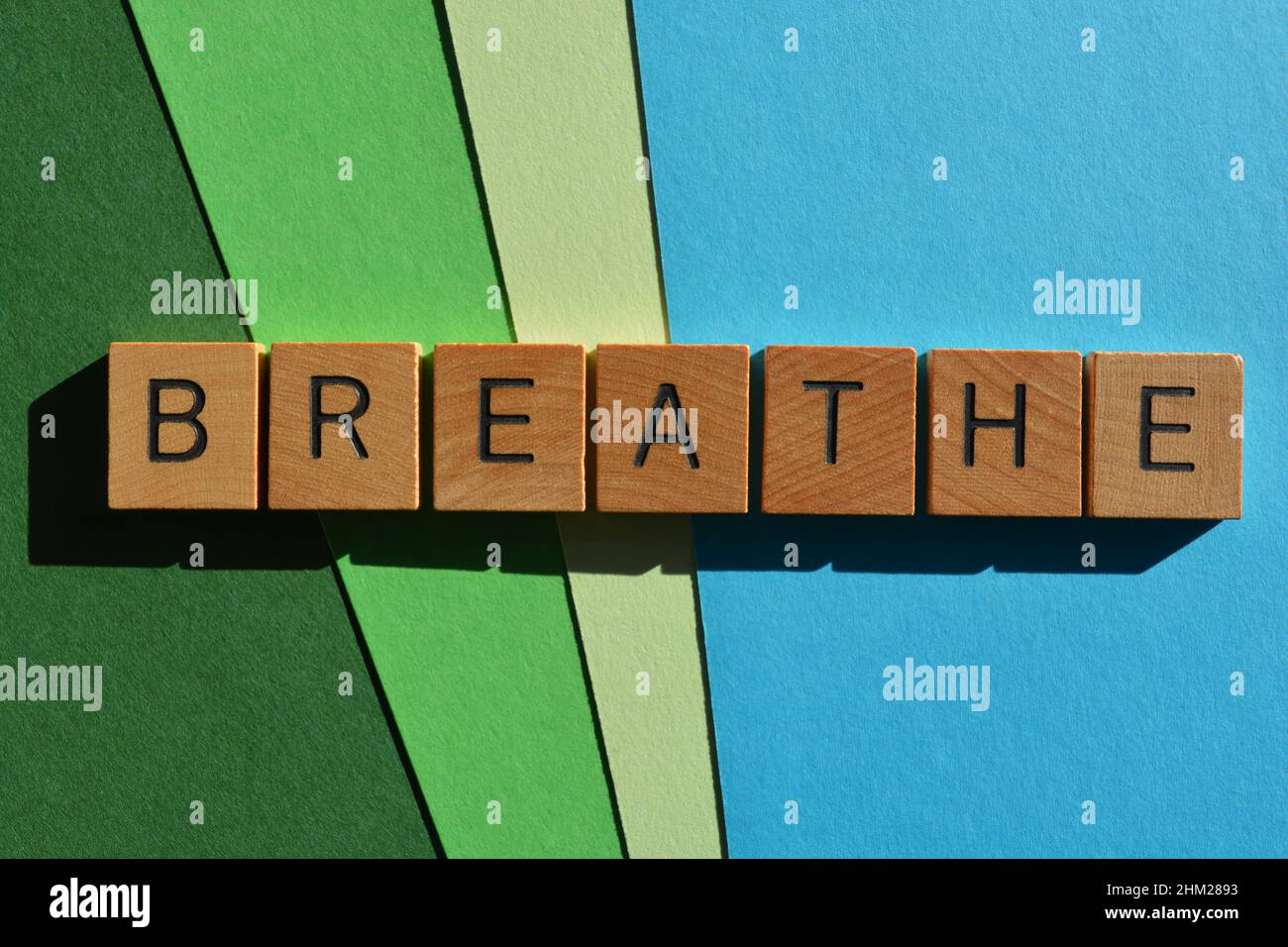 Breathe, word in wooden alphabet letters isolated on green and blue ...