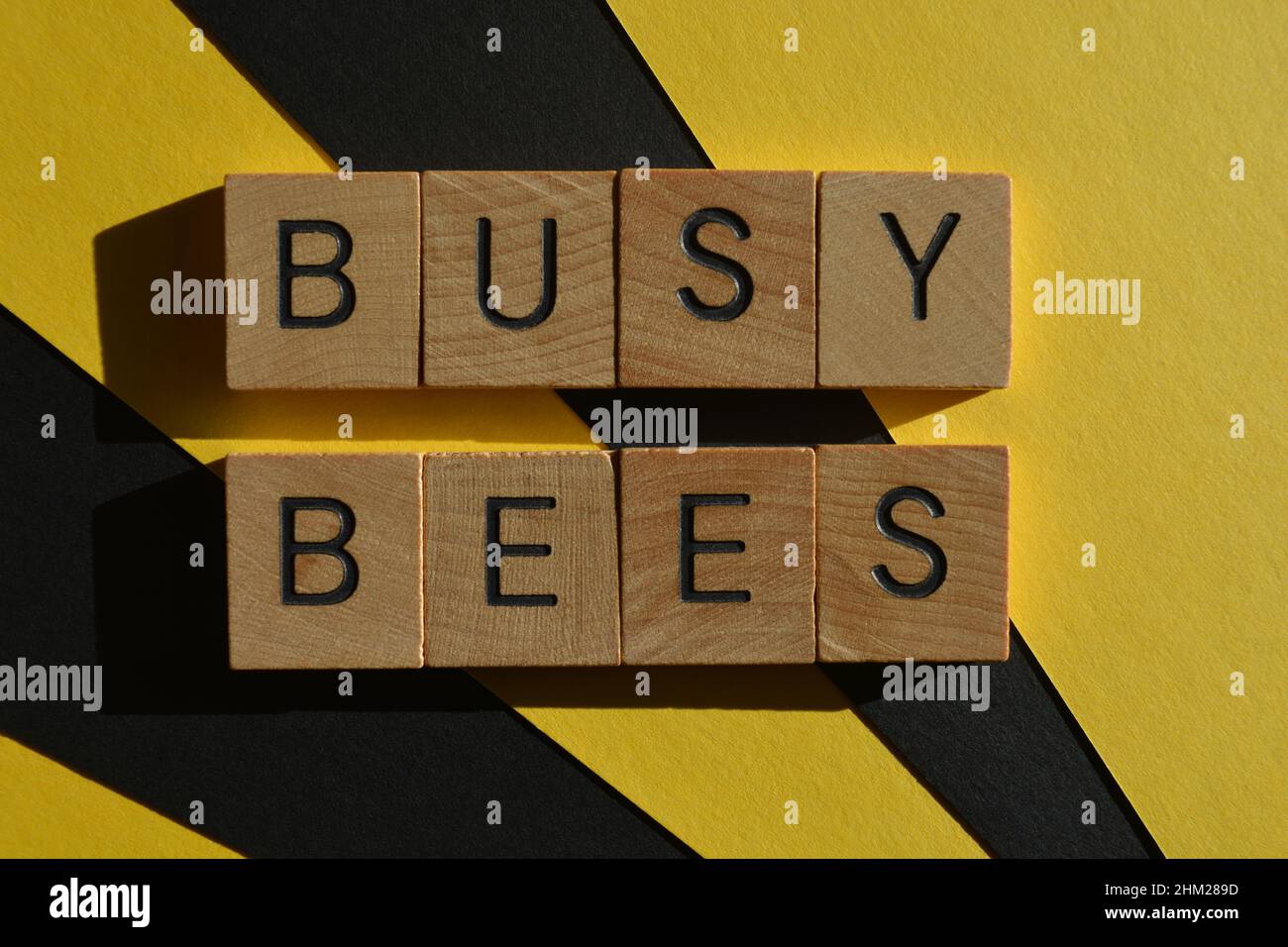 Busy Bees, words in wooden alphabet letters isolated on black and ...