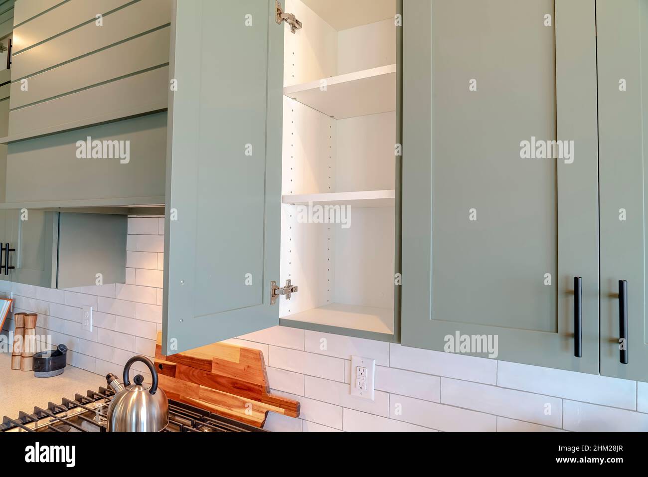 Kitchen wall cabinet with open door and empty shelves against white ...