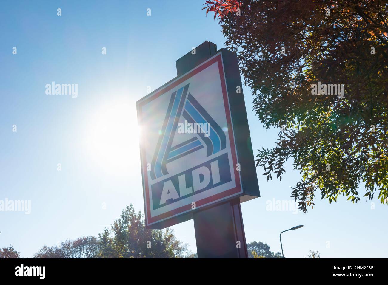 Aldi sign (north division) against blue sky with sunlight. Aldi is a ...