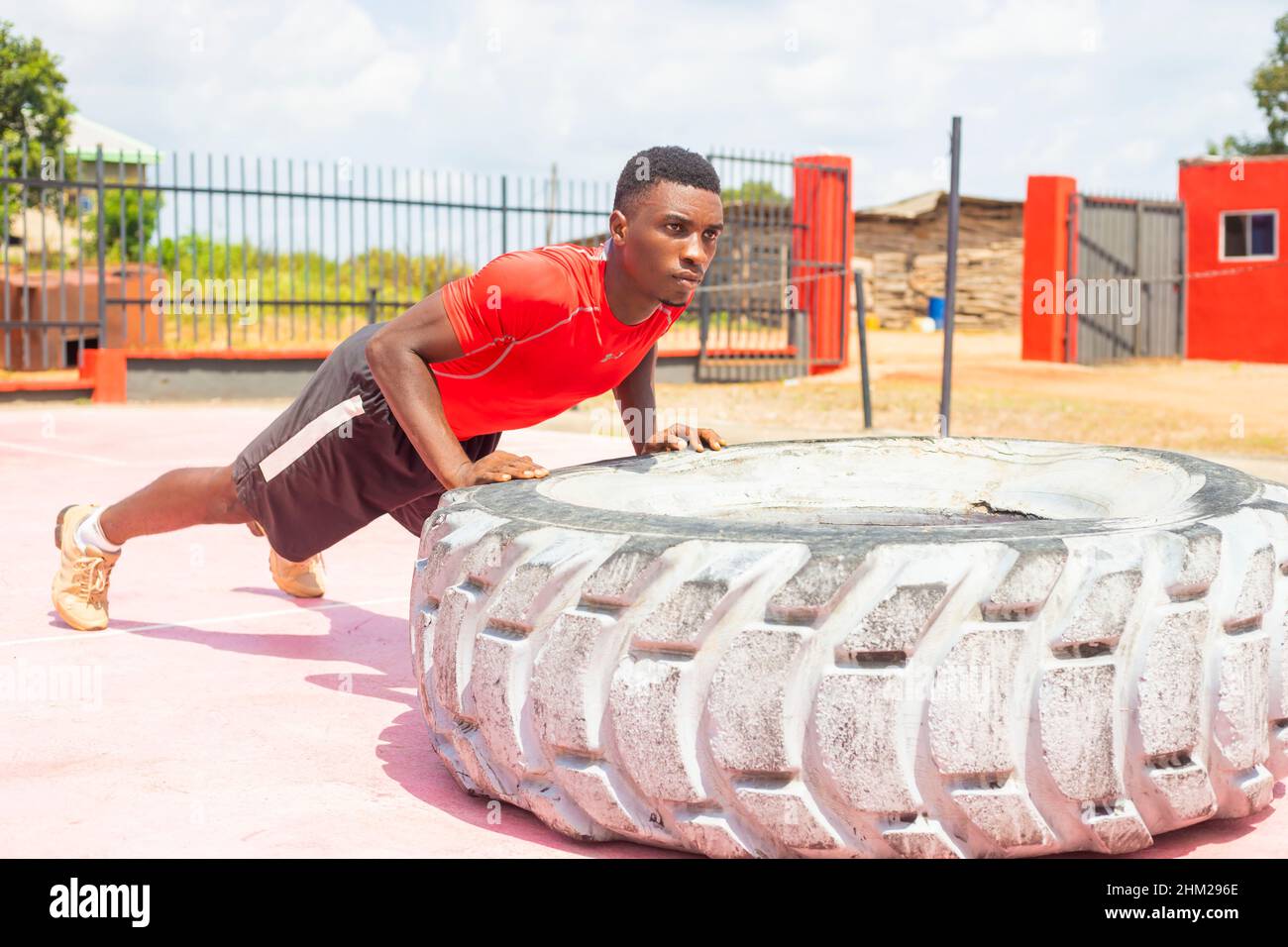 Strong sporty guy flipping workout wheel at outside gym Stock Photo - Alamy
