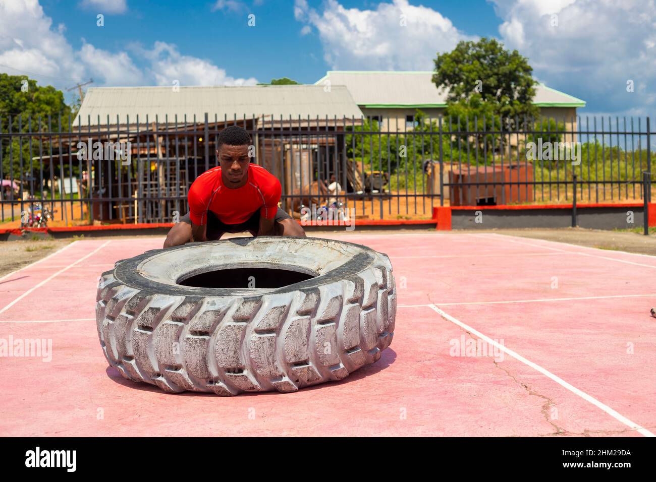 african Muscular man working out in gym flipping big tire Stock Photo ...