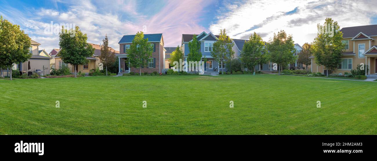 Green lawn field in the middle of traditional houses at Daybreak, Utah ...