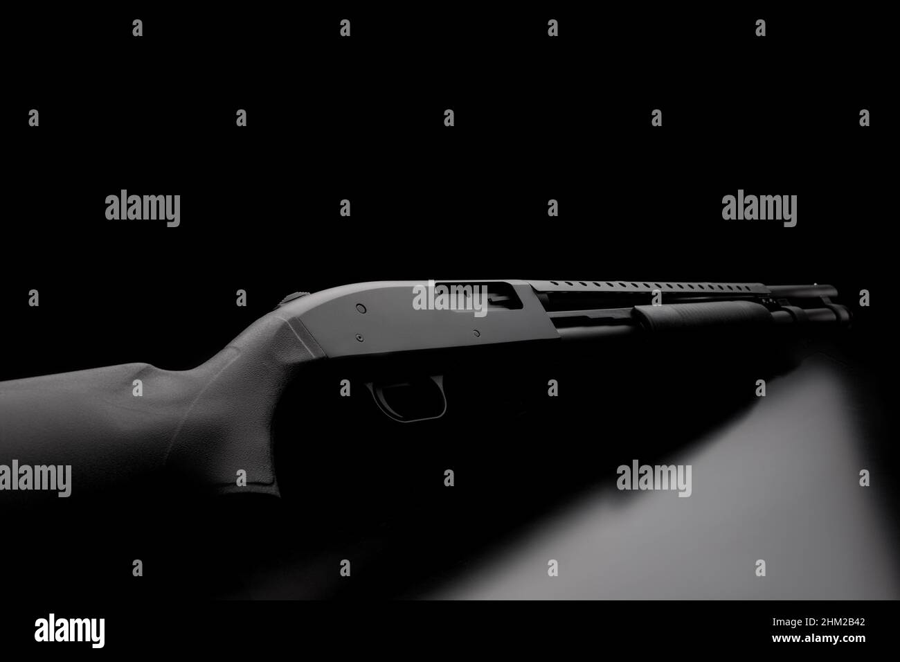 Pump-action 12 gauge shotgun on a dark background. A smooth-bore weapon ...