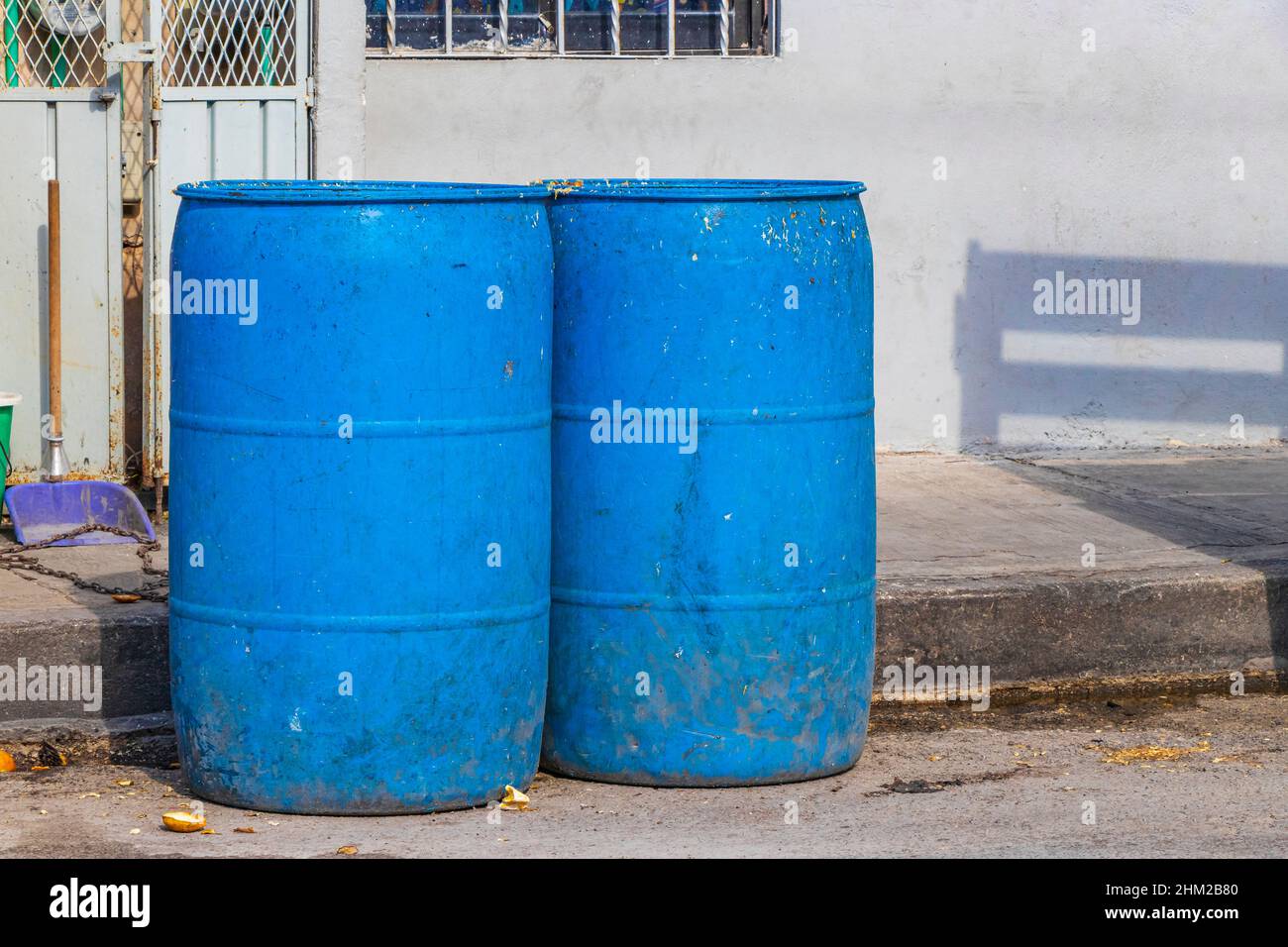 Blue trash waste garbage cans and dirty street in Luis Donaldo Colosio ...