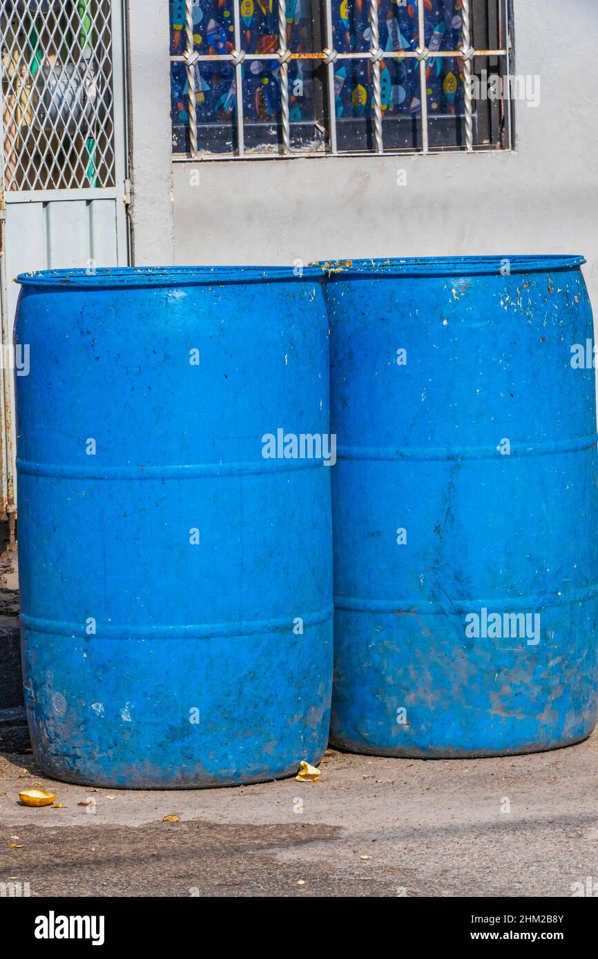 Blue trash waste garbage cans and dirty street in Luis Donaldo Colosio ...