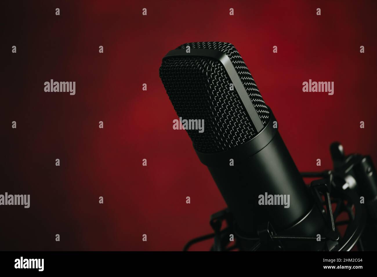 A close up of a streaming microphone over a red background with copy ...