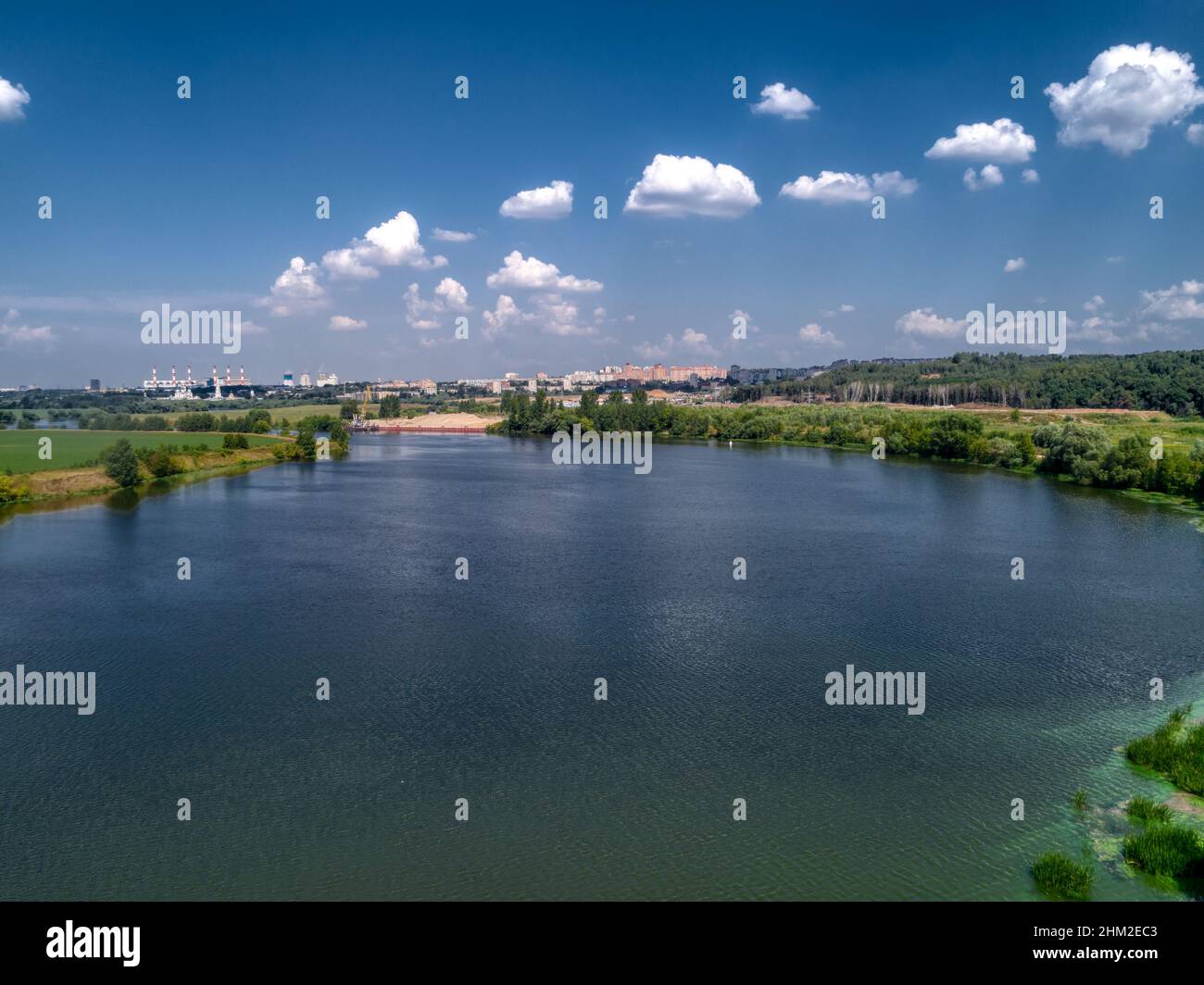 Wide river flowing between fields Stock Photo - Alamy