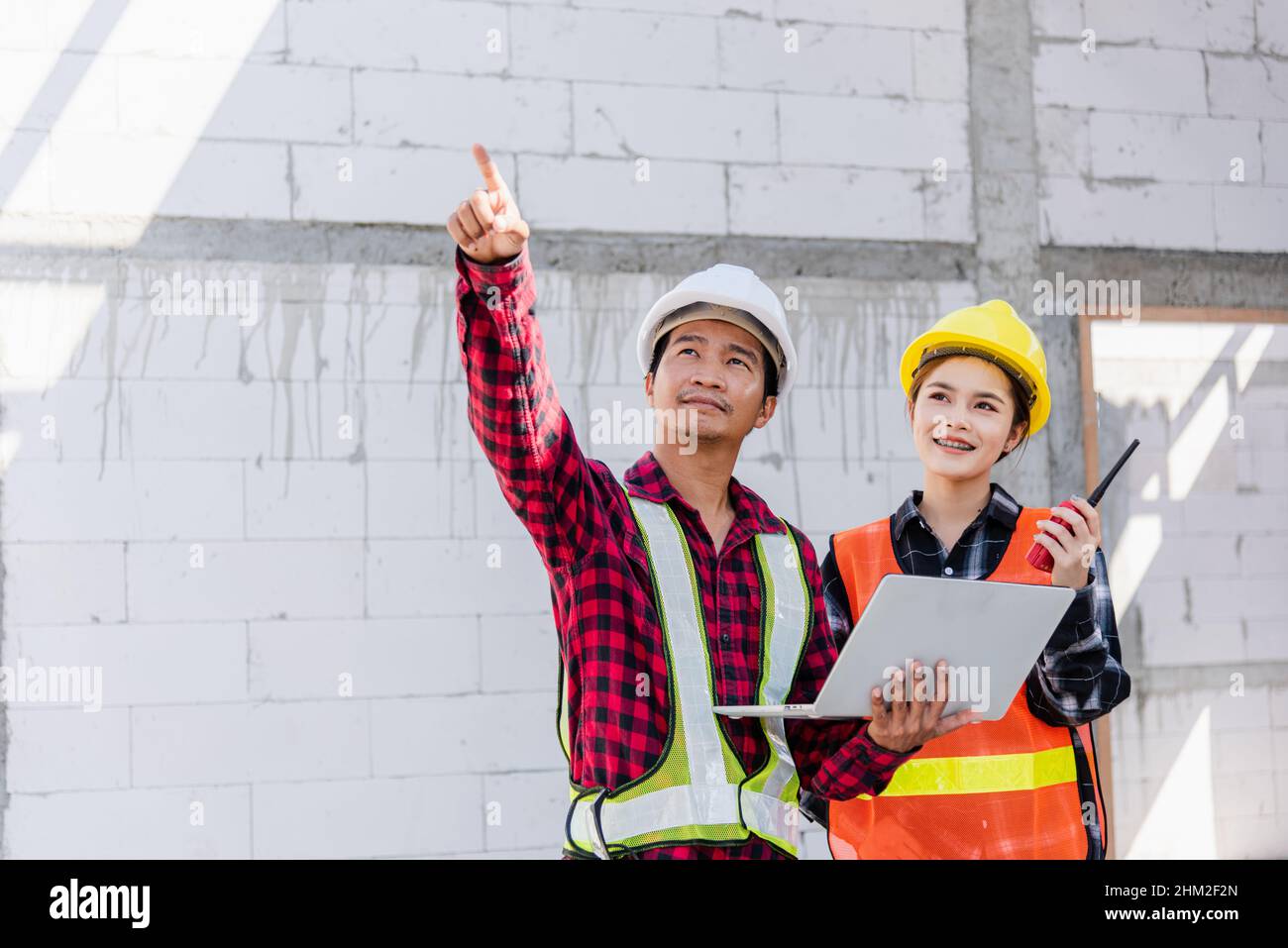 Asian engineer foreman worker man and woman working at building ...