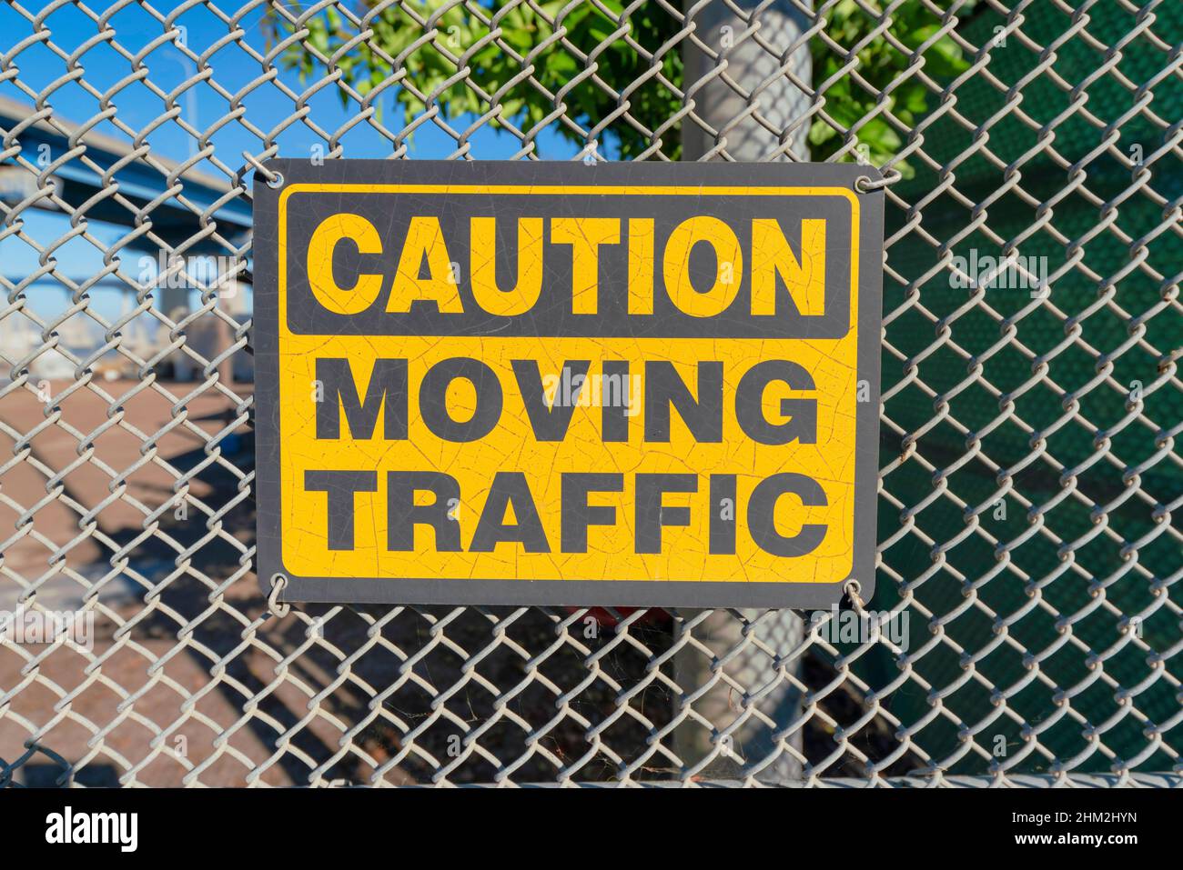 Caution moving traffic sign on a mesh fence at Coronado, San Diego ...