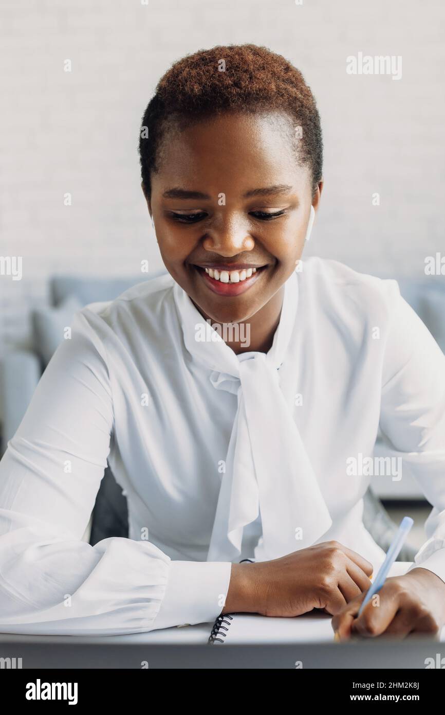 Afro-American woman watching video course in zoom app on office laptop ...