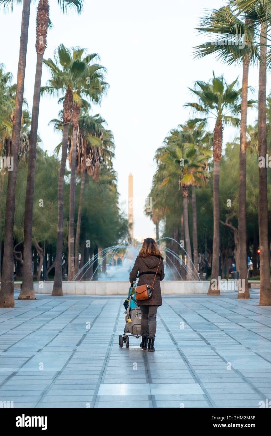 Young woman walking next to the palm trees in the Belen street of the ...
