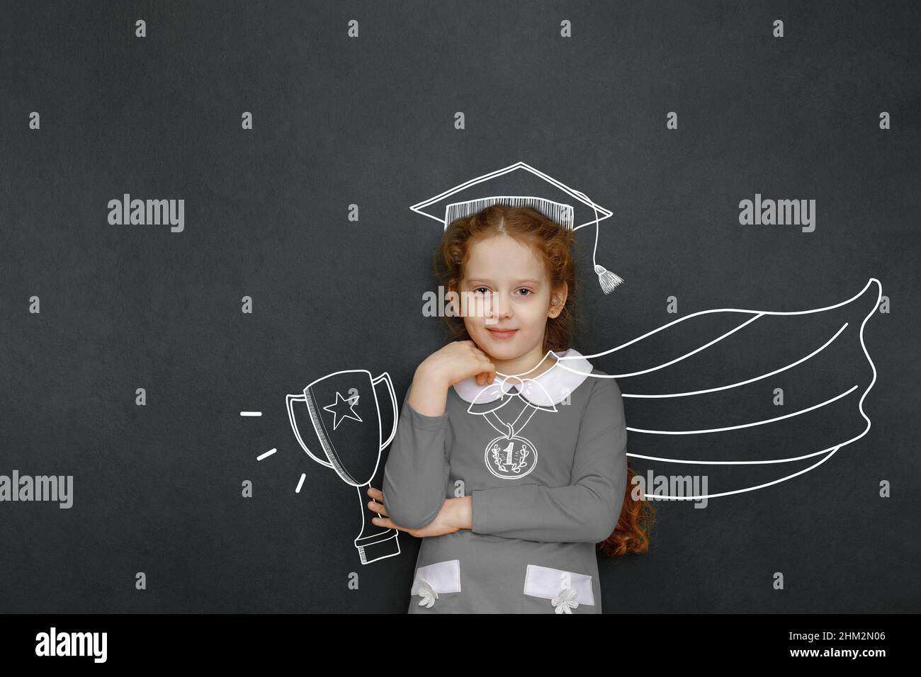 Smart superhero child with Trophy Cup near chalkboard in classroom ...