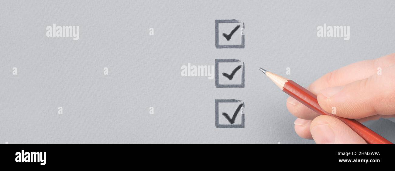hand with pencil writing check mark on Checklist. Hand with pencil and ...