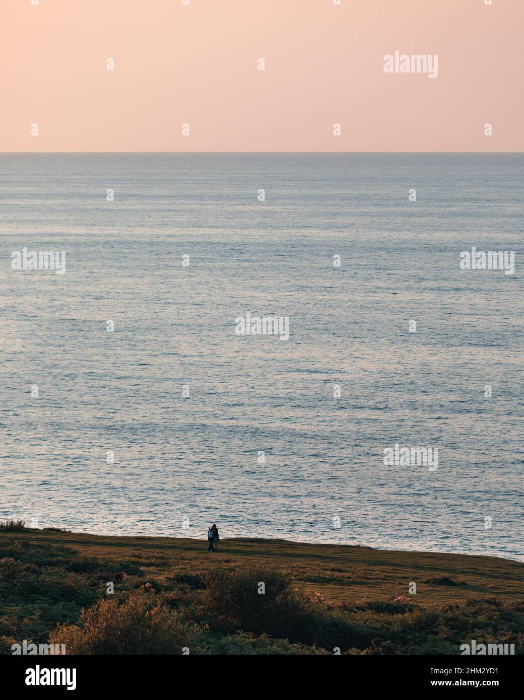 Beautiful view of humans in a field looking to the sea Stock Photo - Alamy