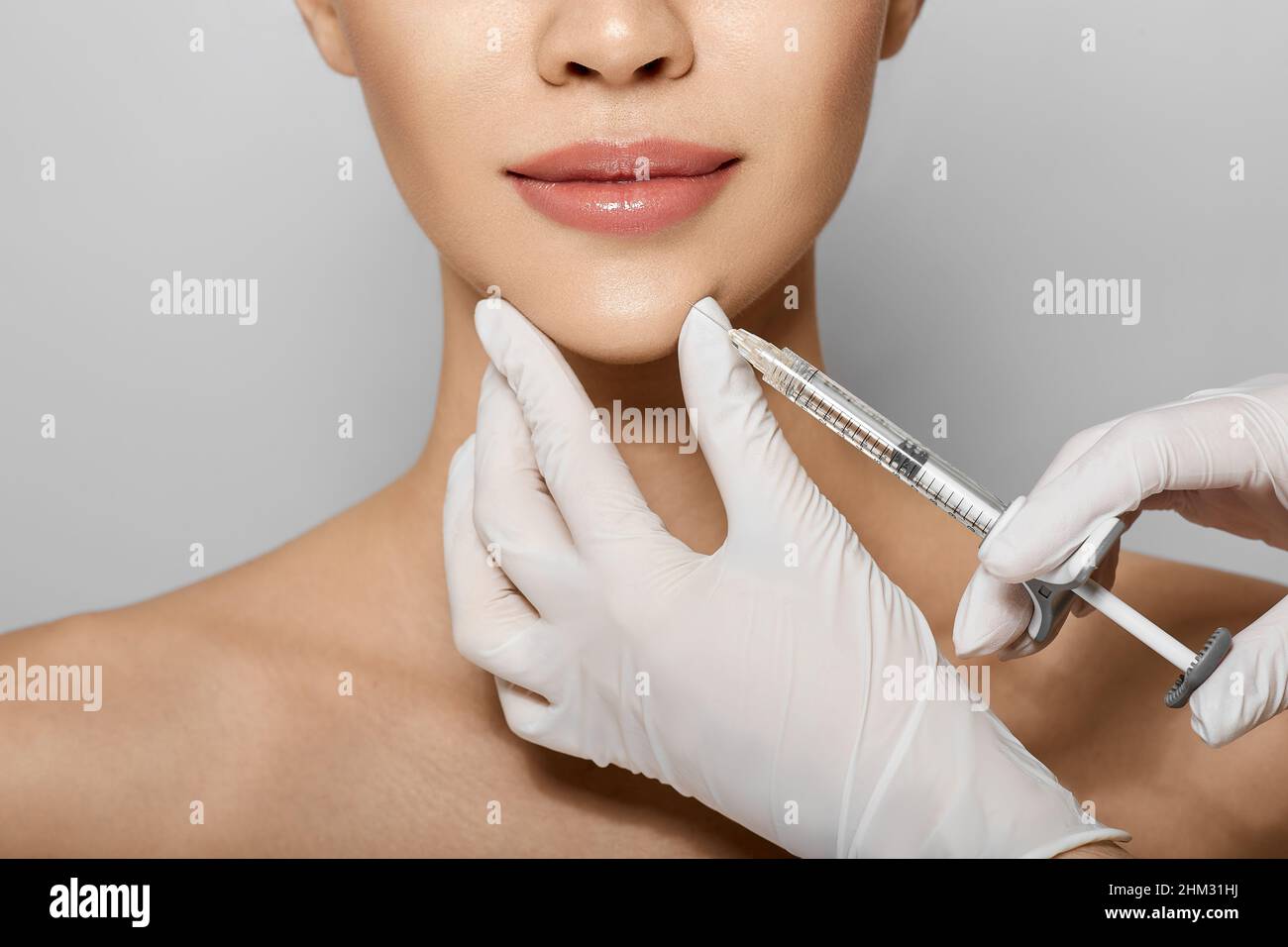 Syringe near woman's chin, beauty injections with fillers for chin ...