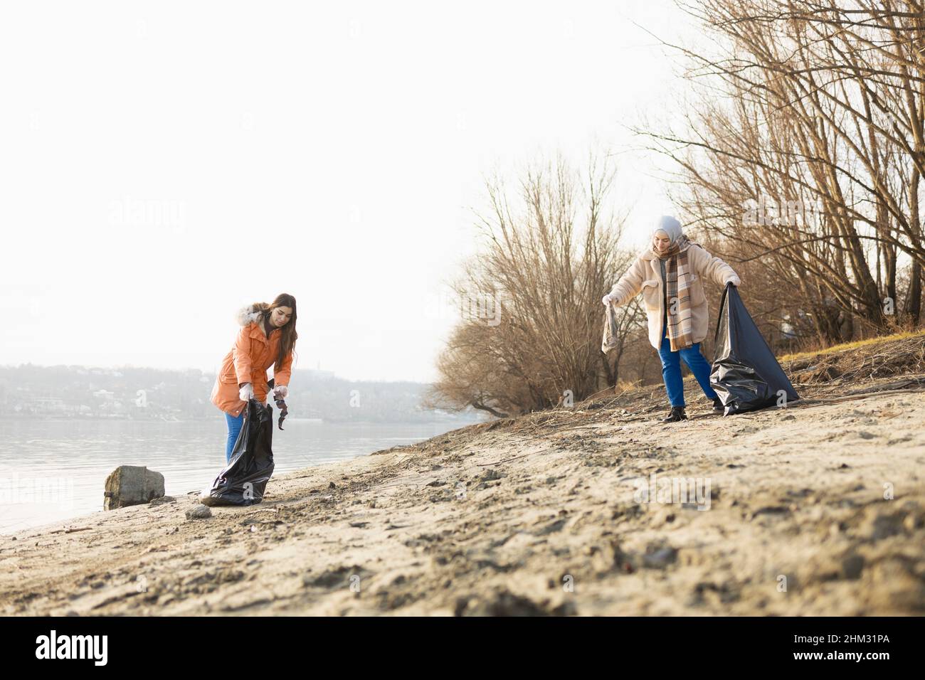 Volunteer team cleaning up rubbish from the beach Stock Photo - Alamy