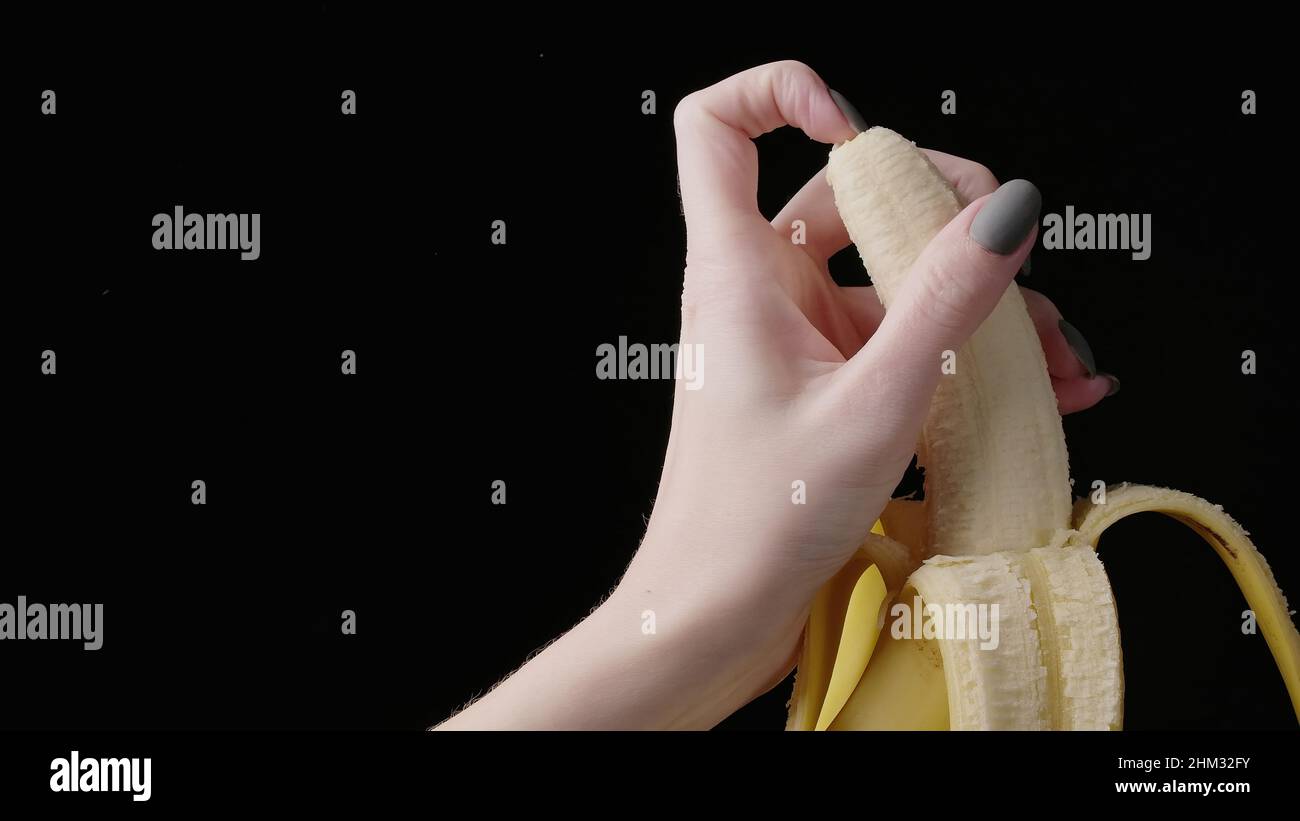 Shooting of the female hand breaking banana Stock Photo - Alamy