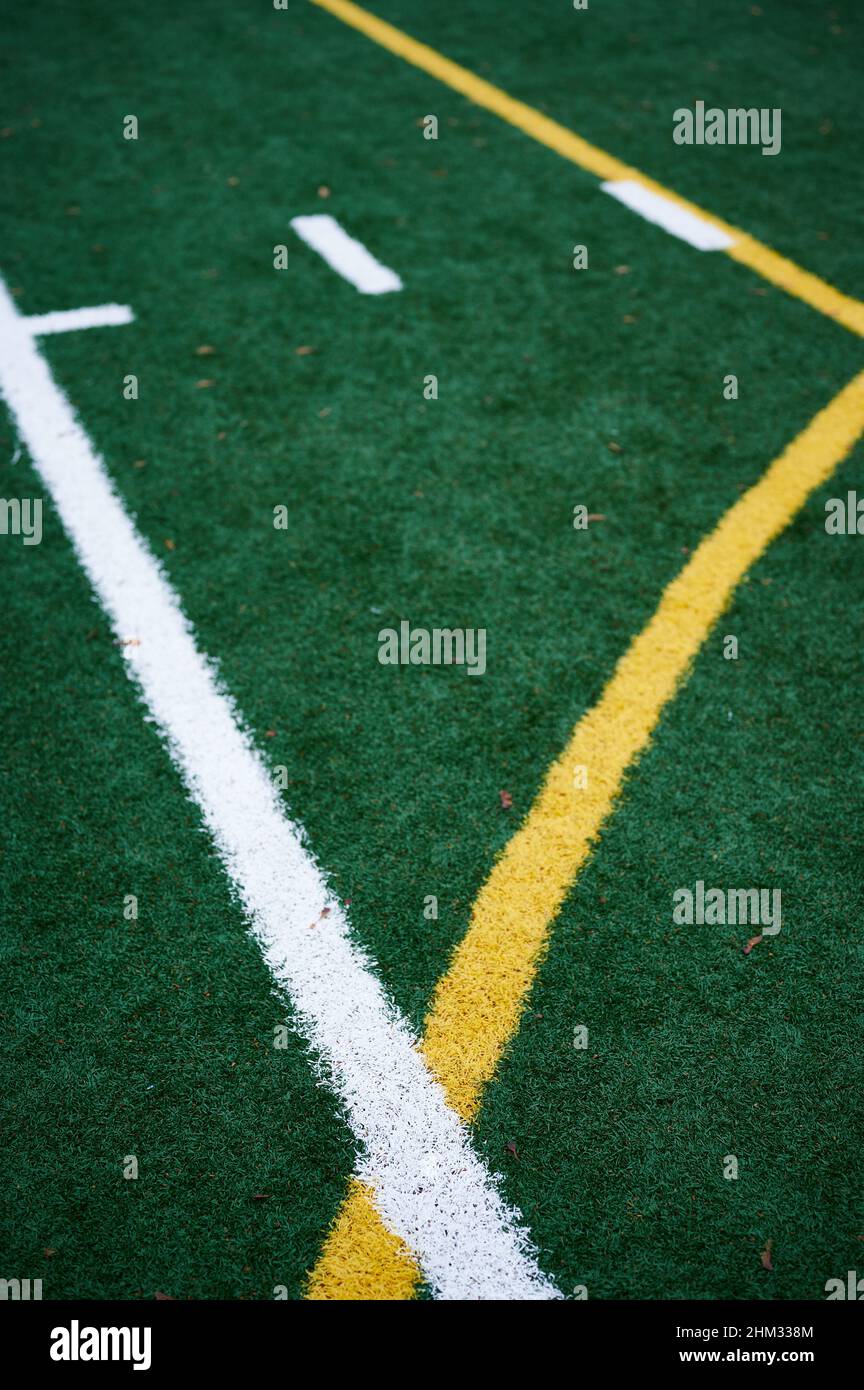 View of green turf grass texture with white and yellow lines in soccer ...