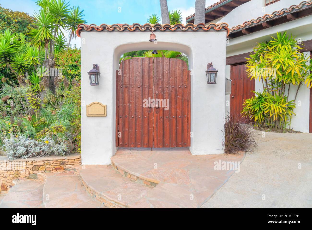 Wooden arbor gate with wall lamps on the white posts at La Jolla, San ...