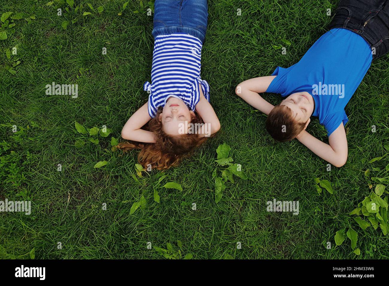 Children friends resting on lawn Stock Photo - Alamy