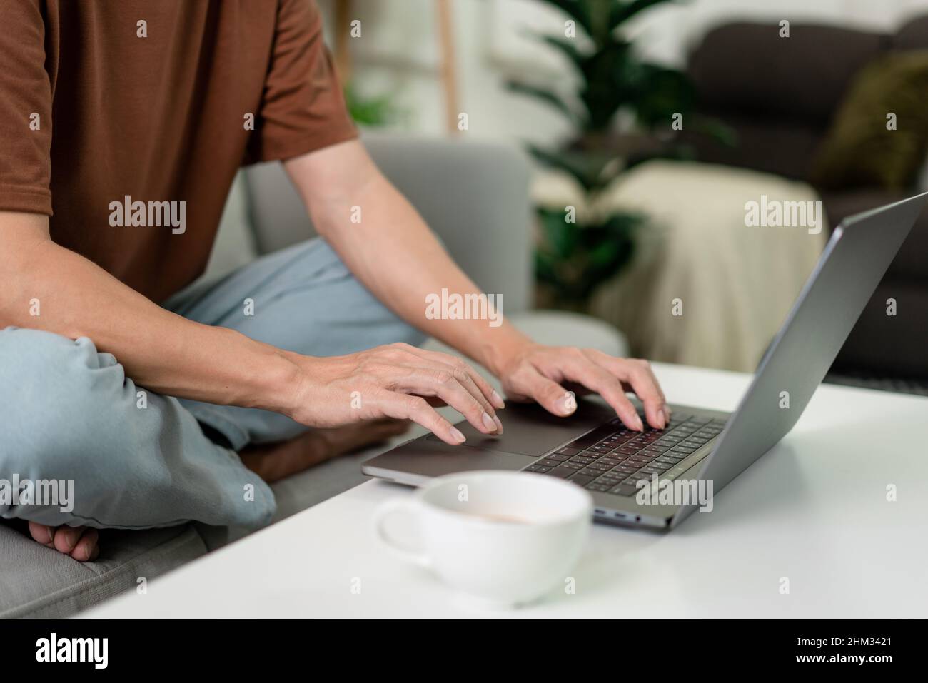 Technology Concept The man in brown T-shirt concentrating on typing ...