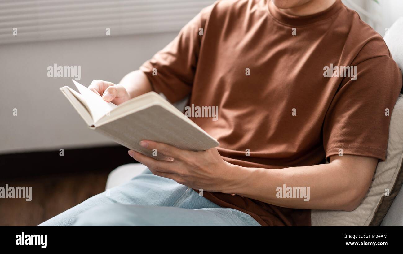 Technology Concept The male with his glasses sitting on the grey sofa ...