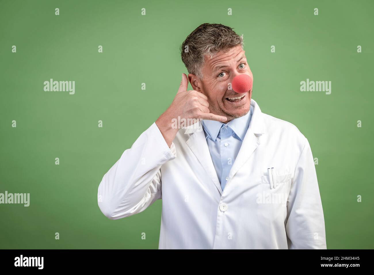 Scientist with white coat has red clown nose on and stands in front of ...