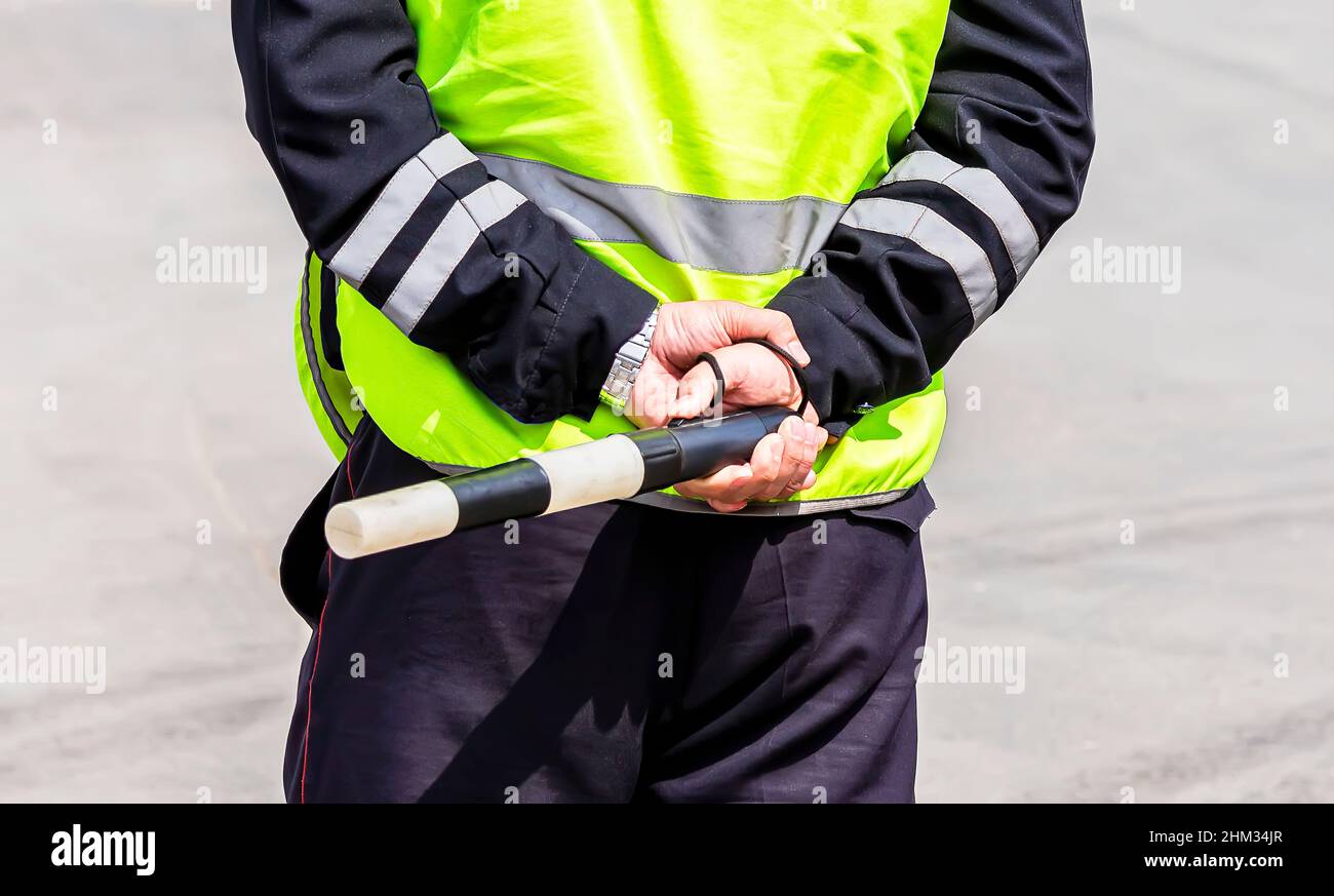 Traffic police baton, with backlight button and strap in the hands of a ...