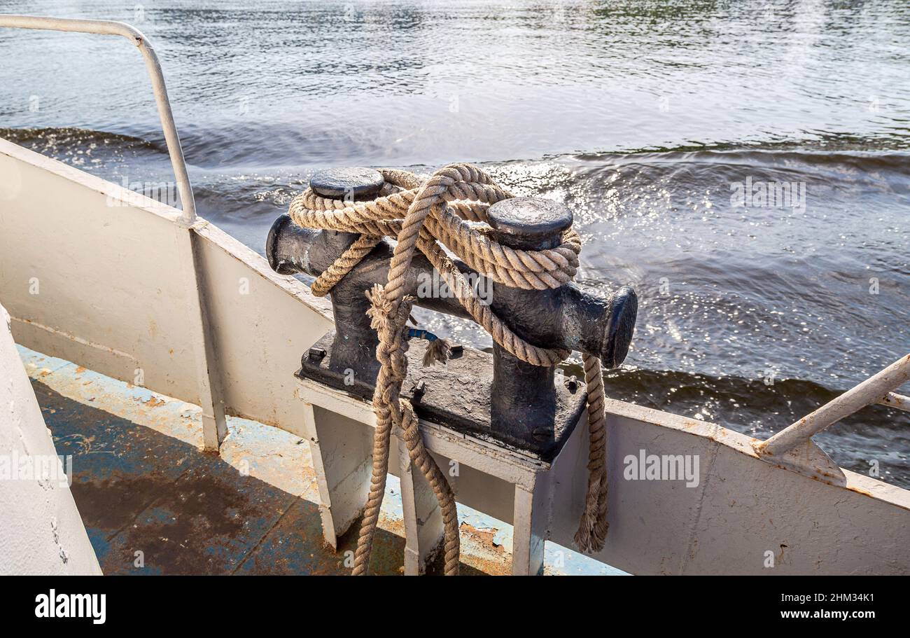 Mooring bollard with a fixed rope on the ship against the water ...
