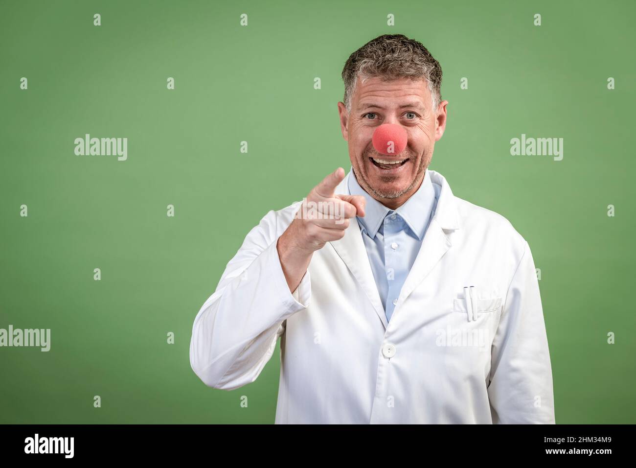 Scientist with white coat has red clown nose on and stands in front of ...