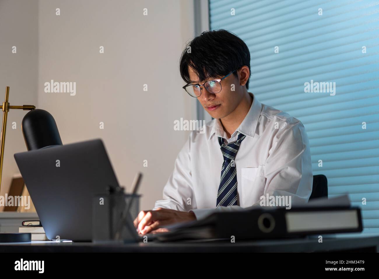 Overwork Concept The man sitting at his desk and focusing on working ...
