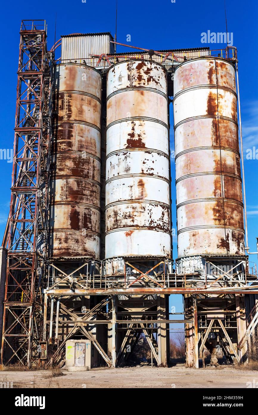 Old, abandoned concrete plant with iron rusty tanks and metal ...