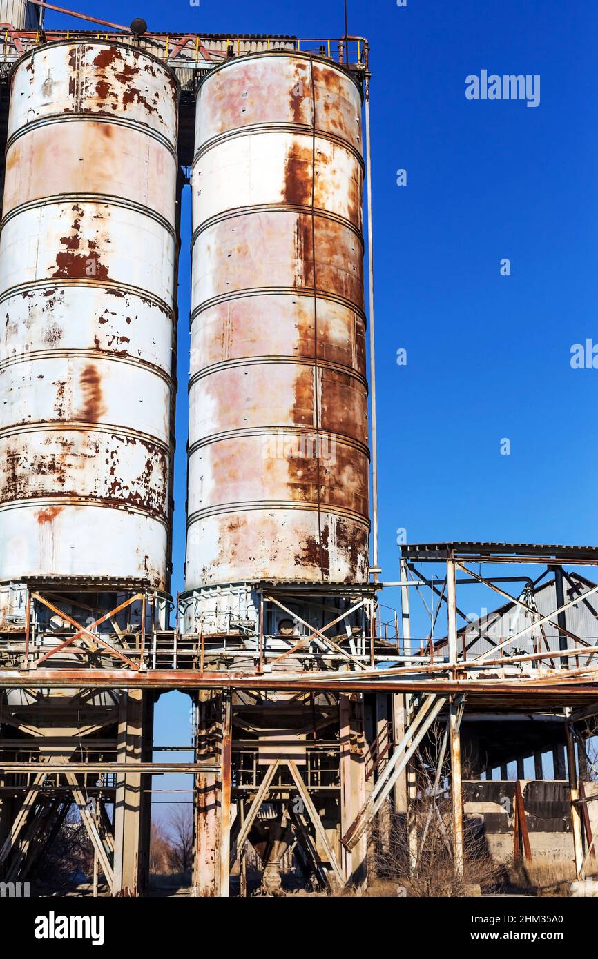 Old, abandoned concrete plant with iron rusty tanks and metal ...