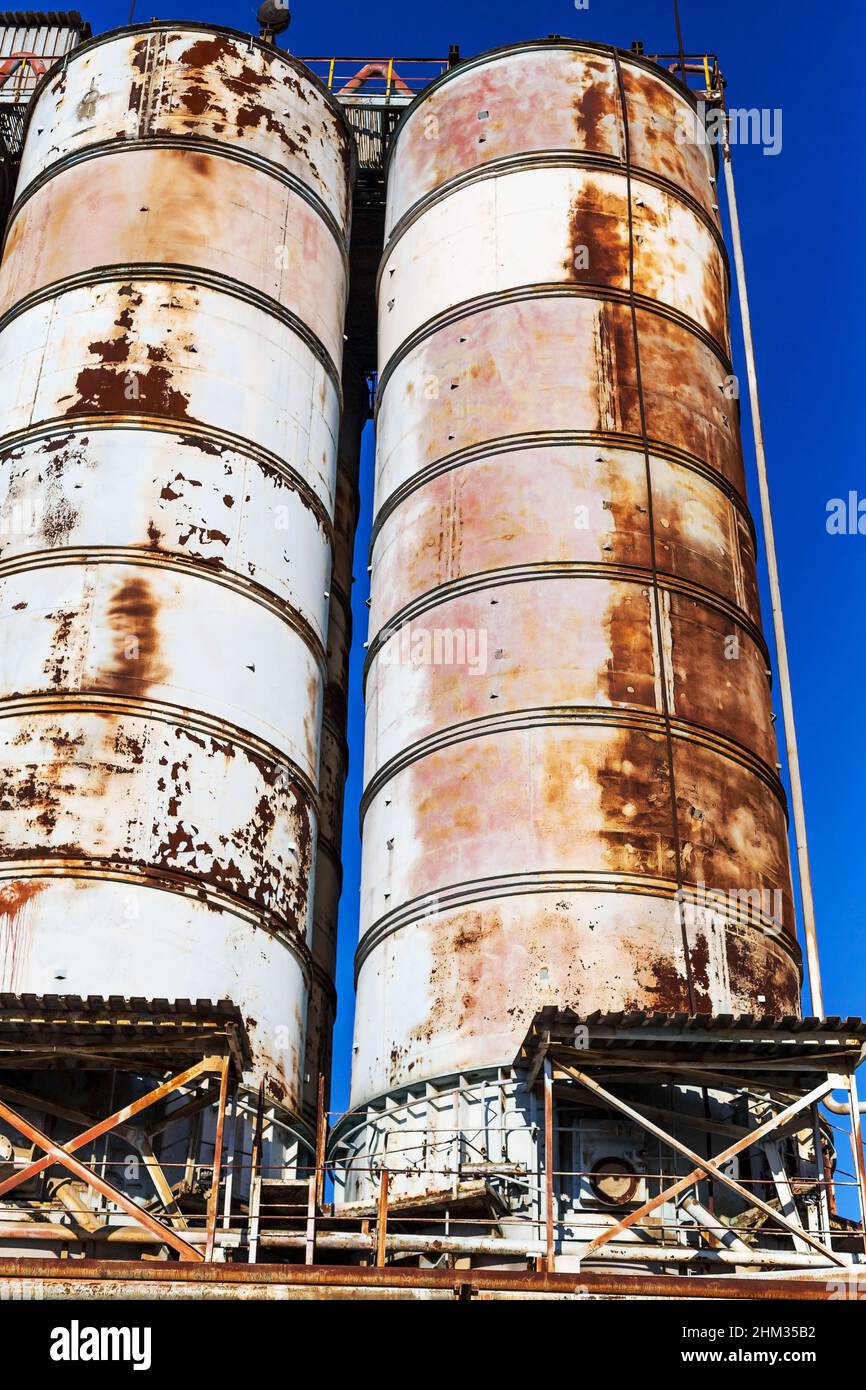 Old, abandoned concrete plant with iron rusty tanks and metal ...