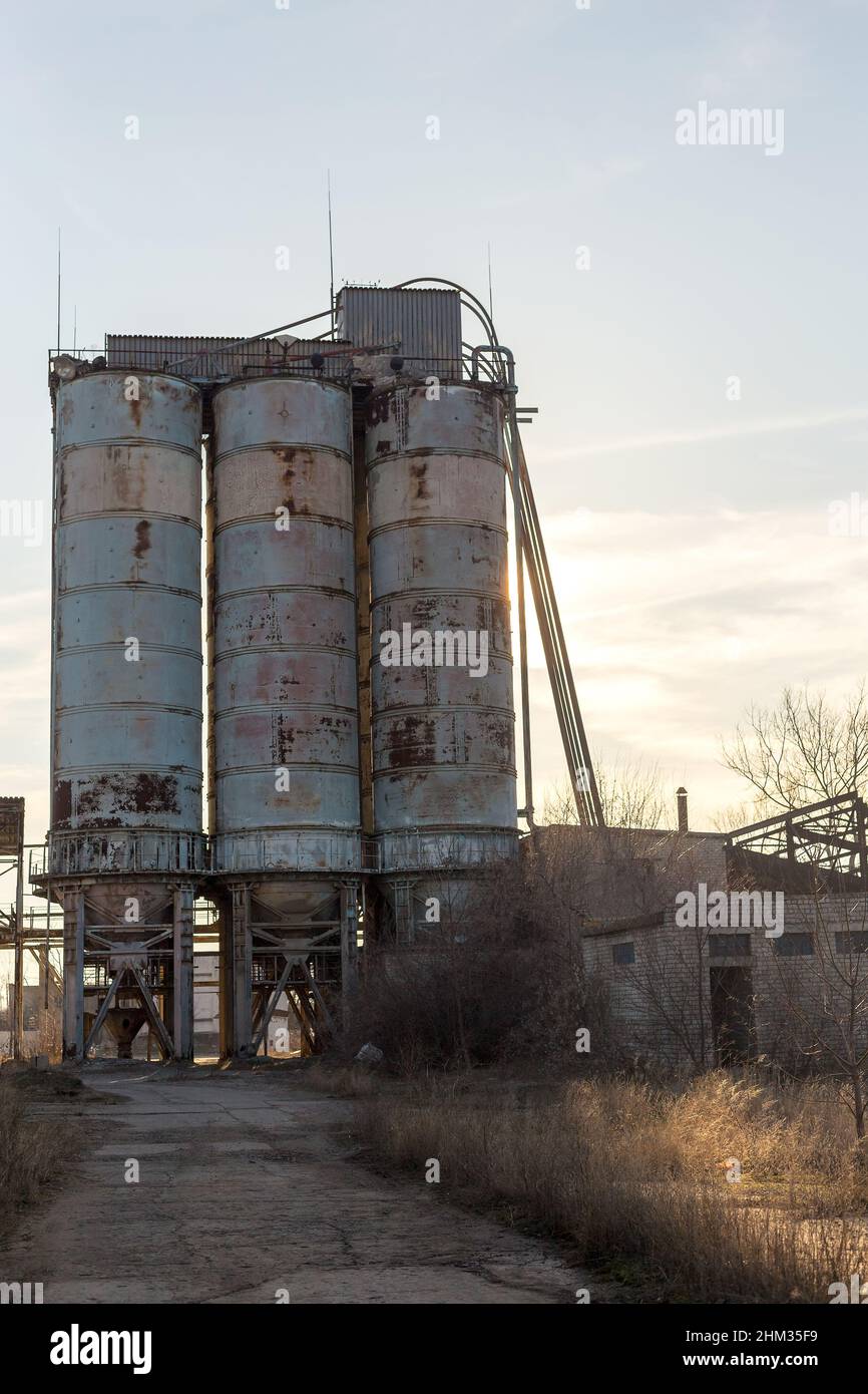 Old, abandoned concrete plant with iron rusty tanks and metal ...