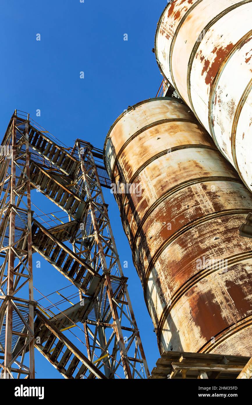 Old, abandoned concrete plant with iron rusty tanks and metal ...
