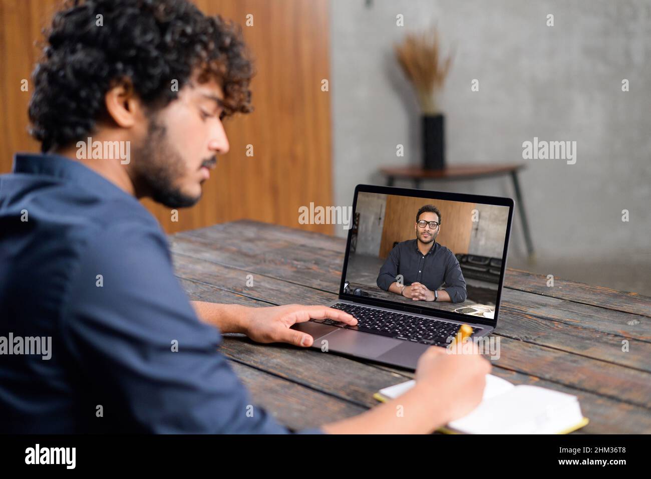 Male student studies online. Young man is watching online classes and ...