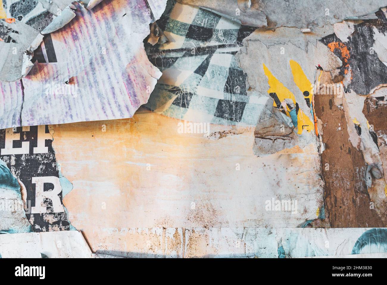 Torn ragged poster paper layers on the wall as grunge background, urban ...