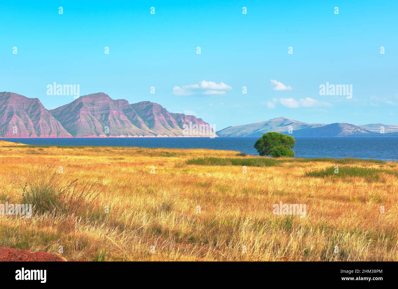 Steppe plain on the background of Mount Tepsey under a blue cloudy sky. Siberia, Russia Stock ...
