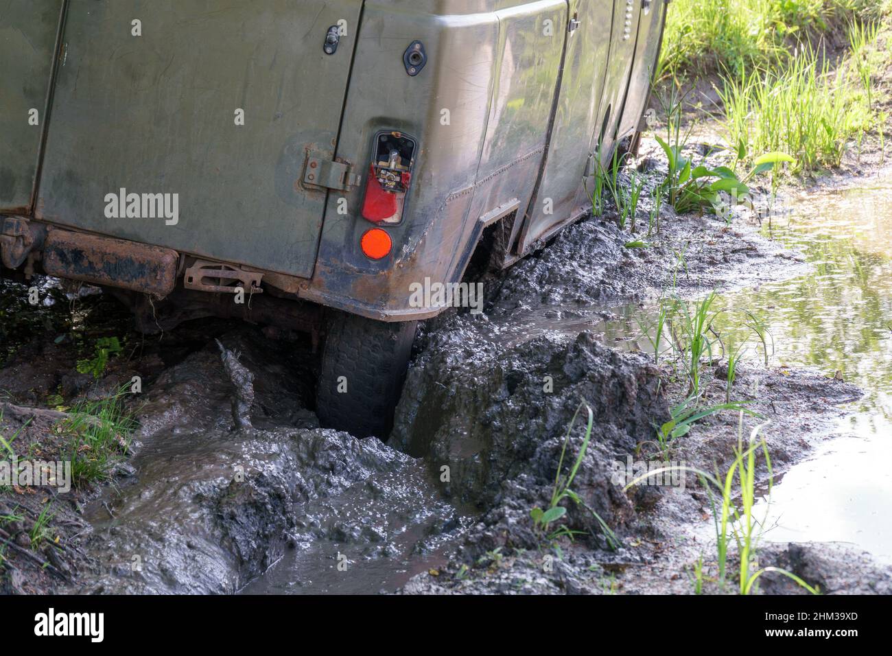 The wheel of an SUV stuck in deep mud on an impassable country road ...
